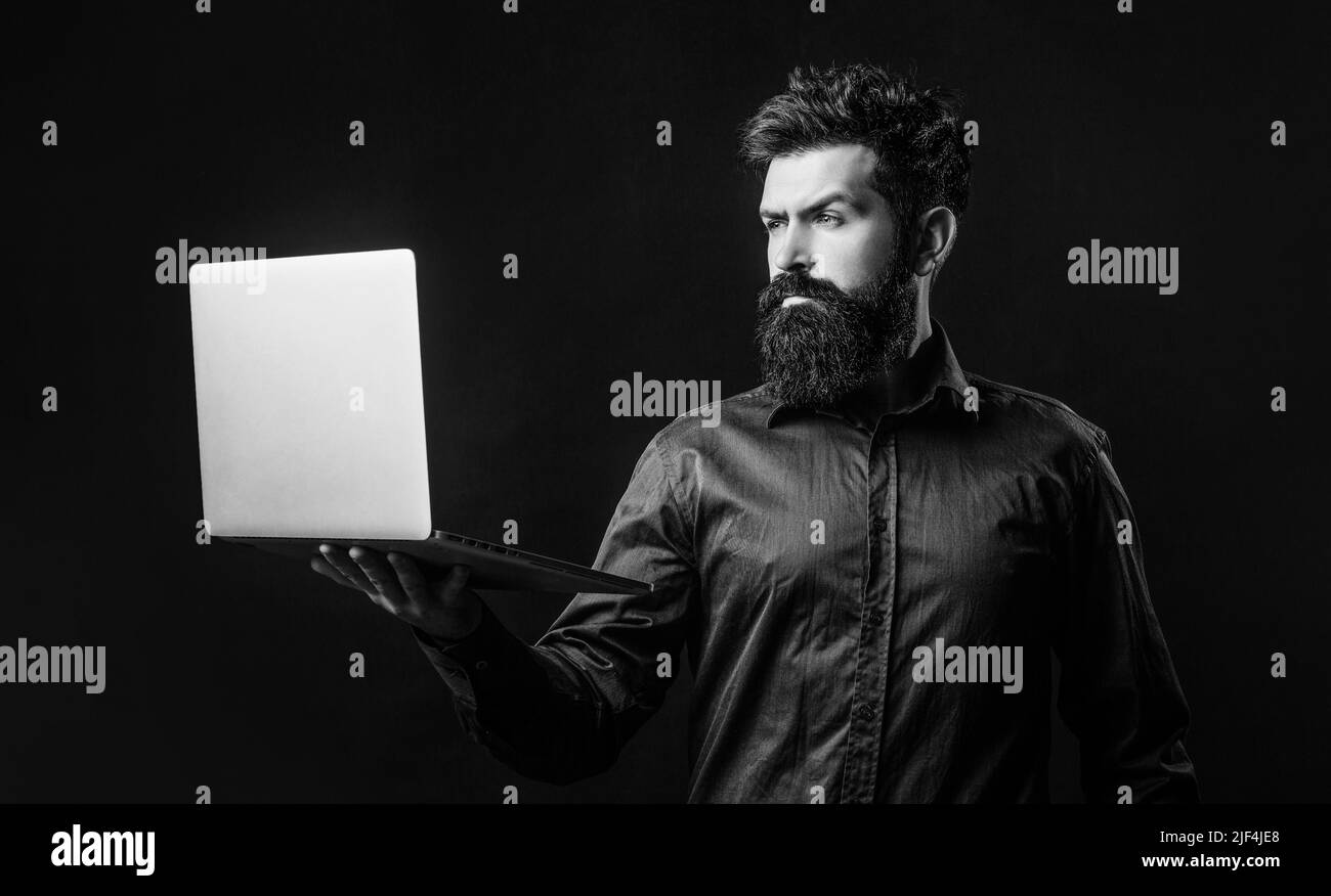 Holding laptop computer. Serious handsome bearded man worker laptop ...