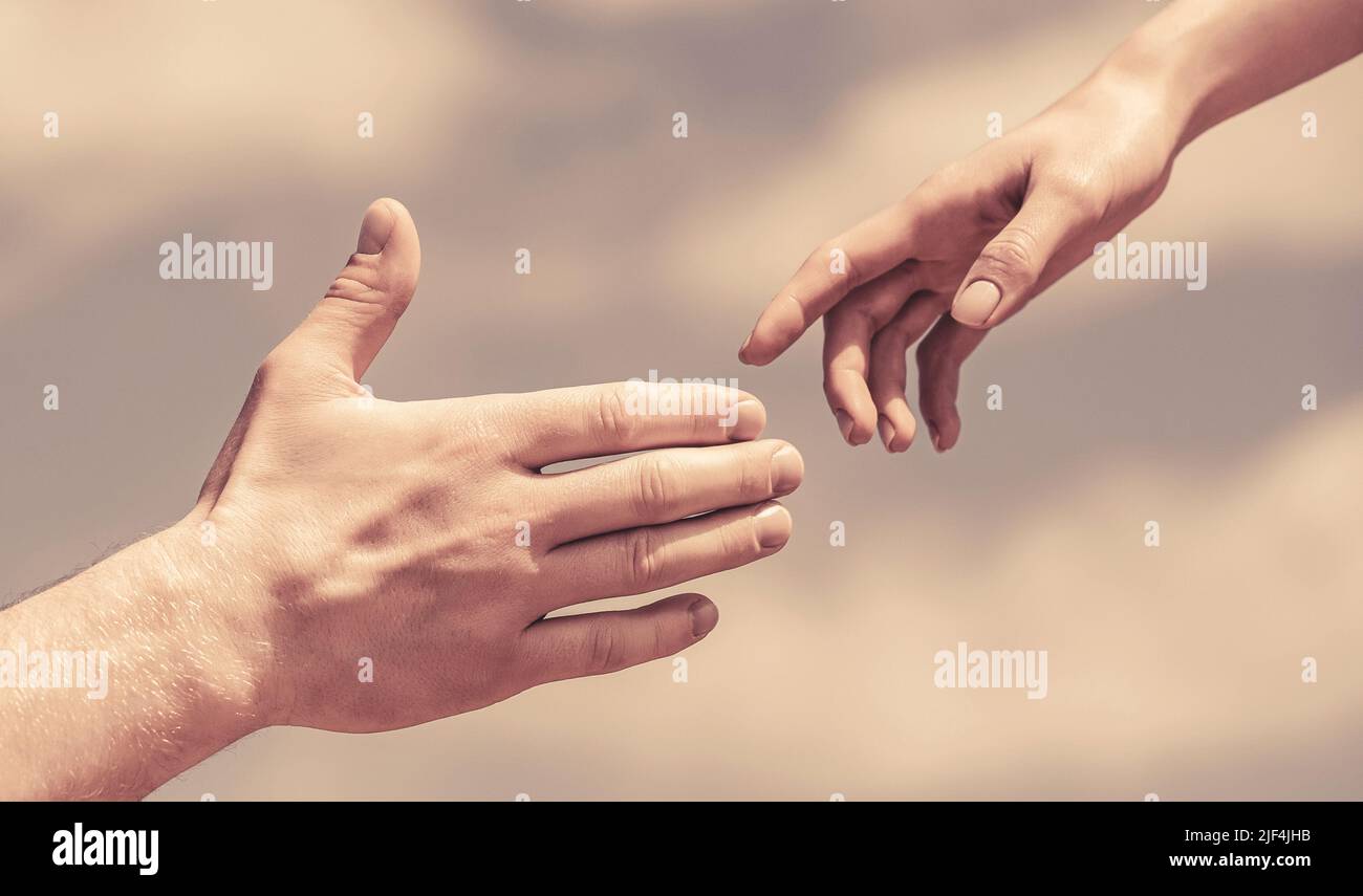 Giving a helping hand. Hands of man and woman on blue sky background ...