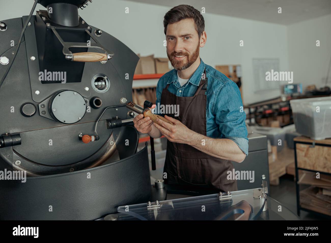 Business owner working with coffee roasting machine on own small ...