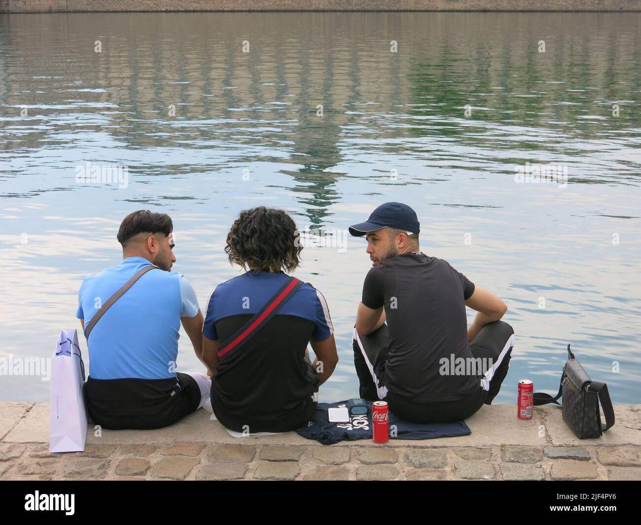 Three young men seated on the banks of the Rhone; the Berges du Rhone ...