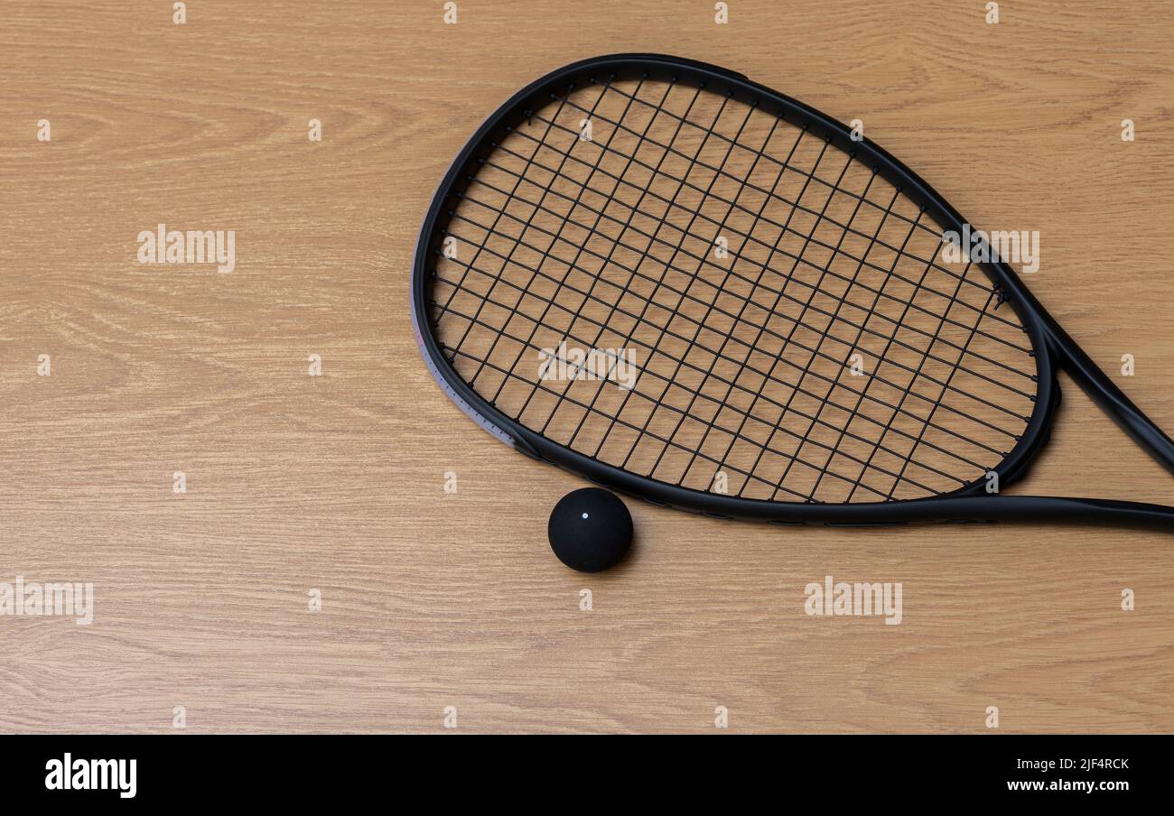 Black squash racket and ball on brown court. Horizontal sport theme ...