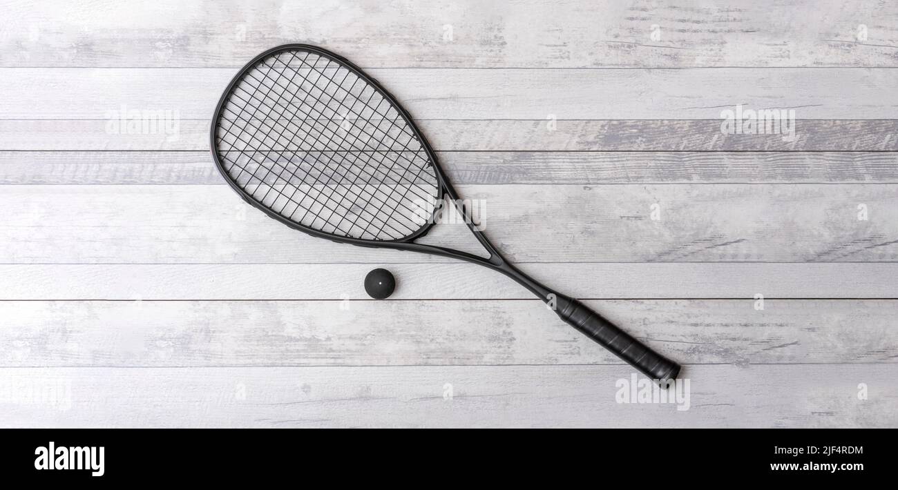 Black squash racket and ball on grey court. Horizontal sport theme ...