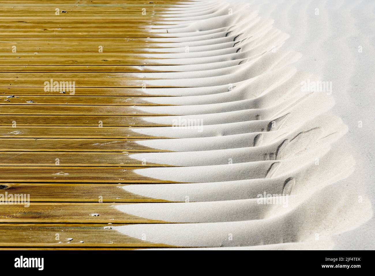 Wind created pattern of light fine beach sand on brown outdoor patio ...