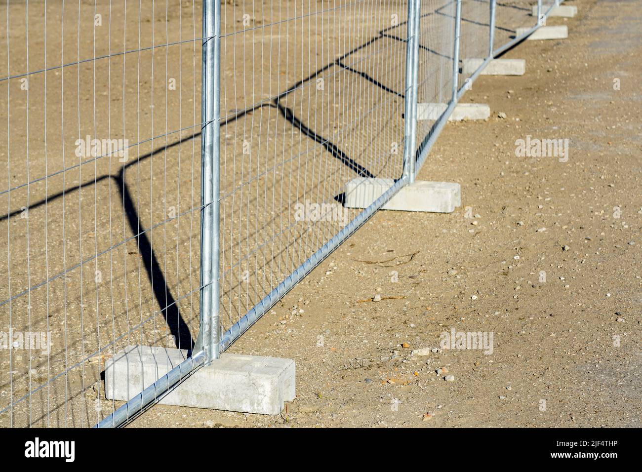 Temporary metal portable fence with concrete base blocks with holes for ...