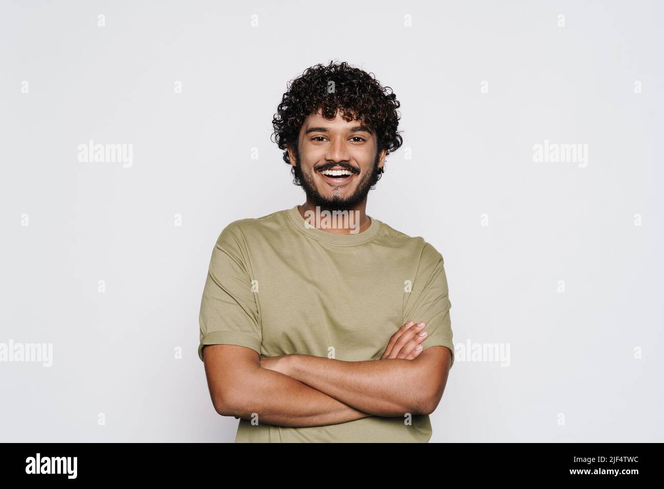 Young middle eastern man smiling while posing with arms crossed ...