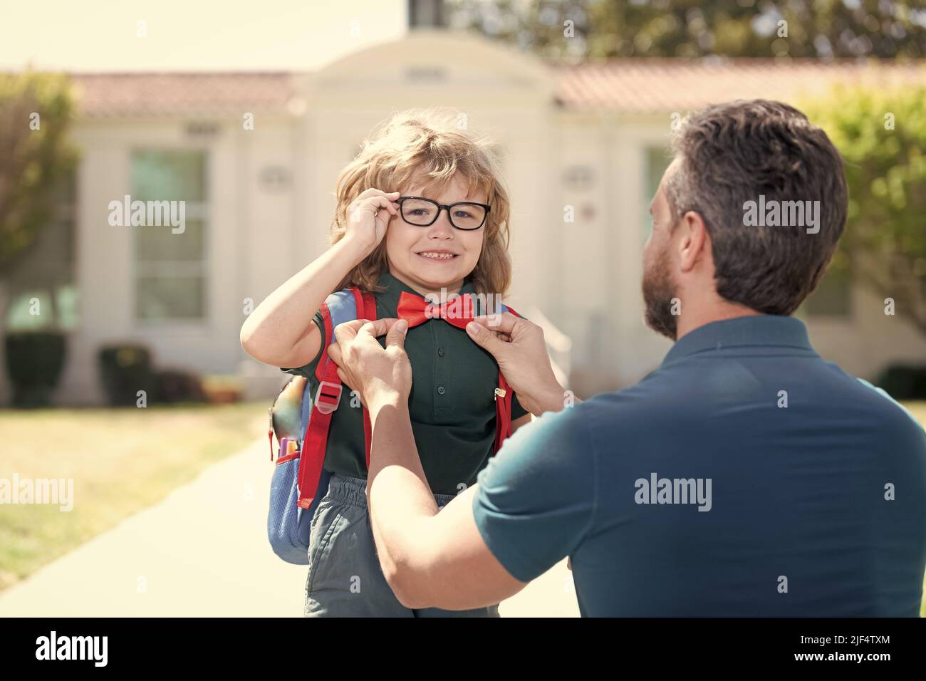 first day at school. father and son come back from school. happy family ...