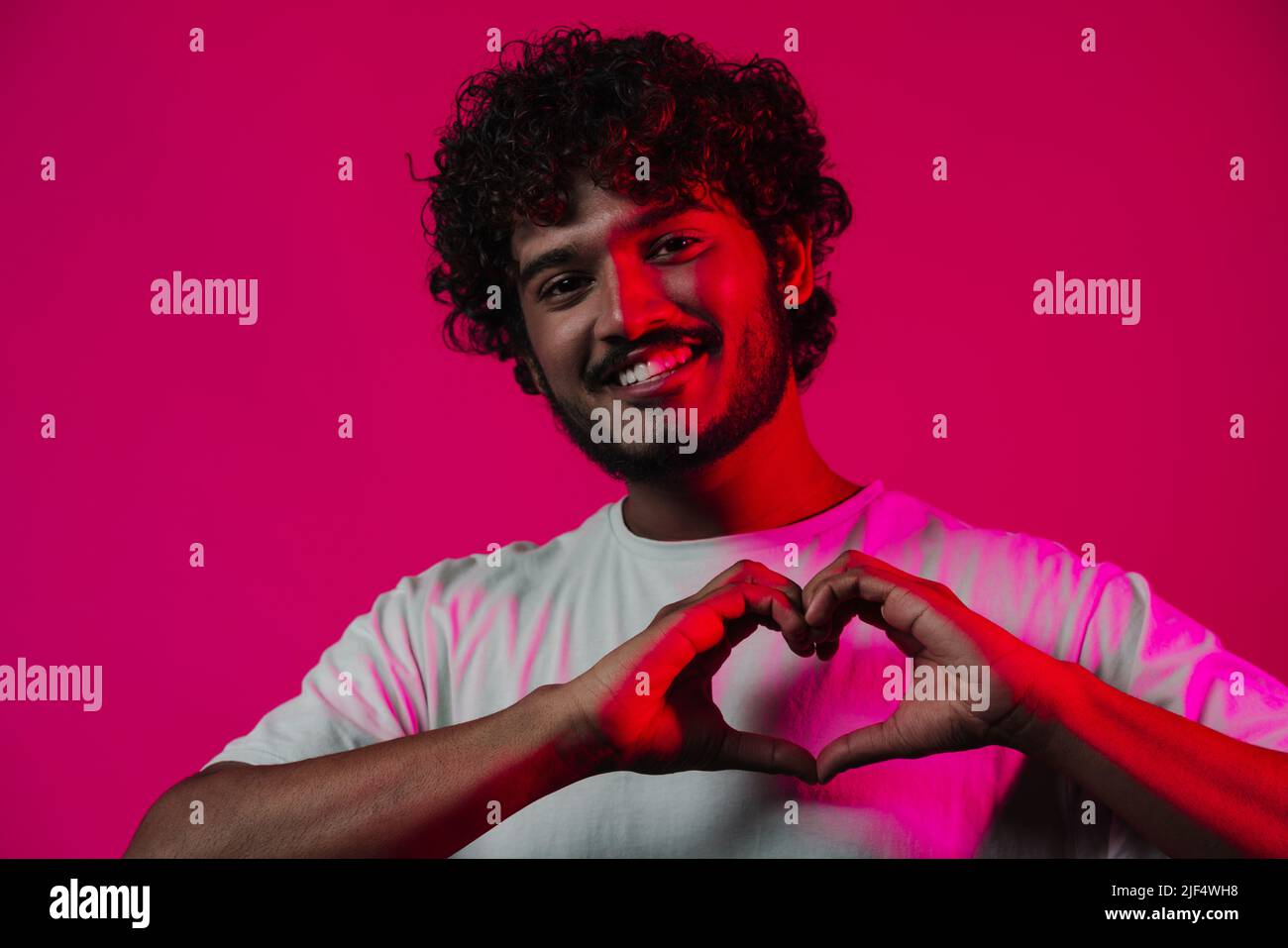 Young middle eastern man smiling and making heart gesture isolated over ...