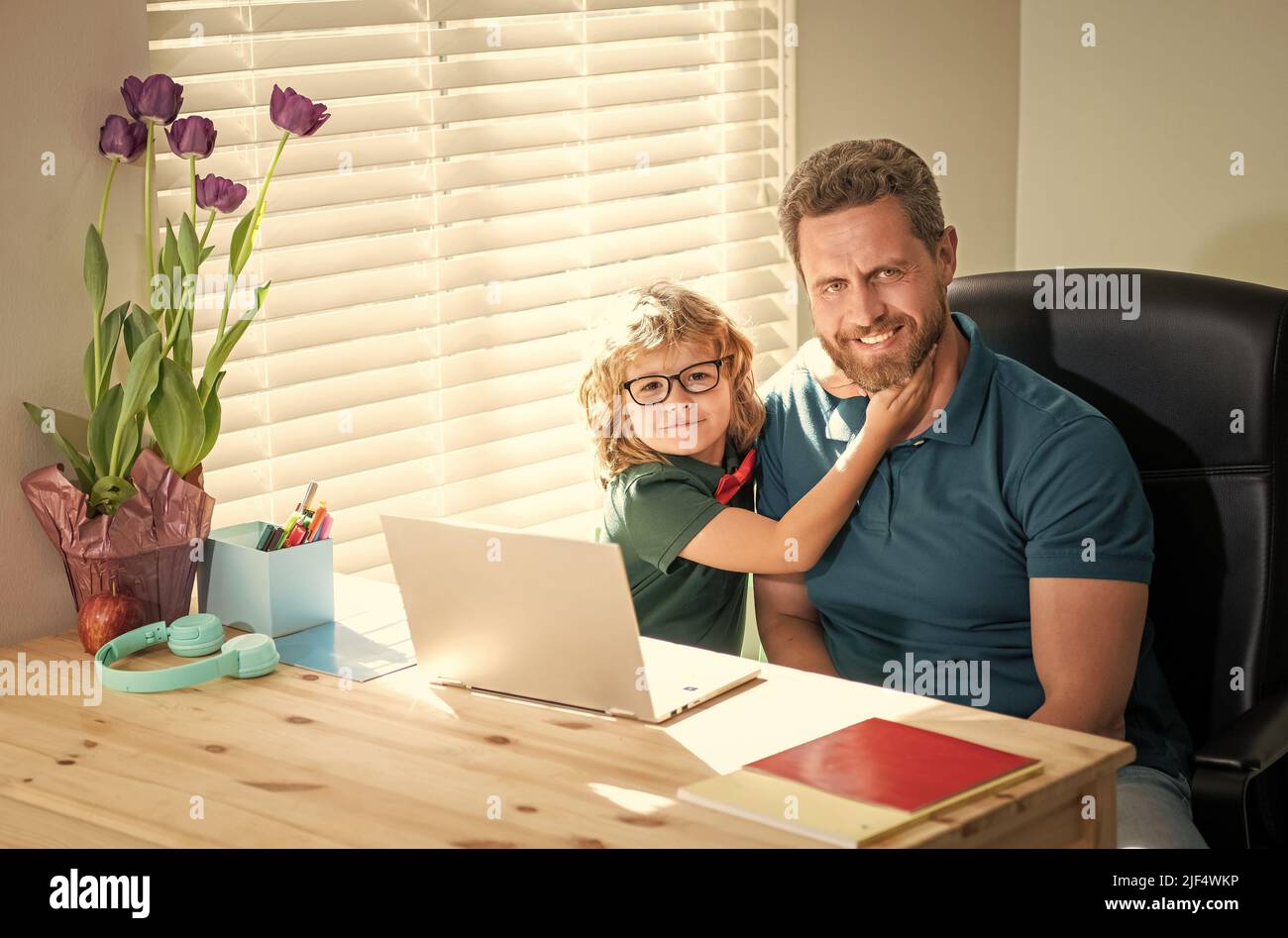 happy dad helping his school son child in glasses study with computer ...