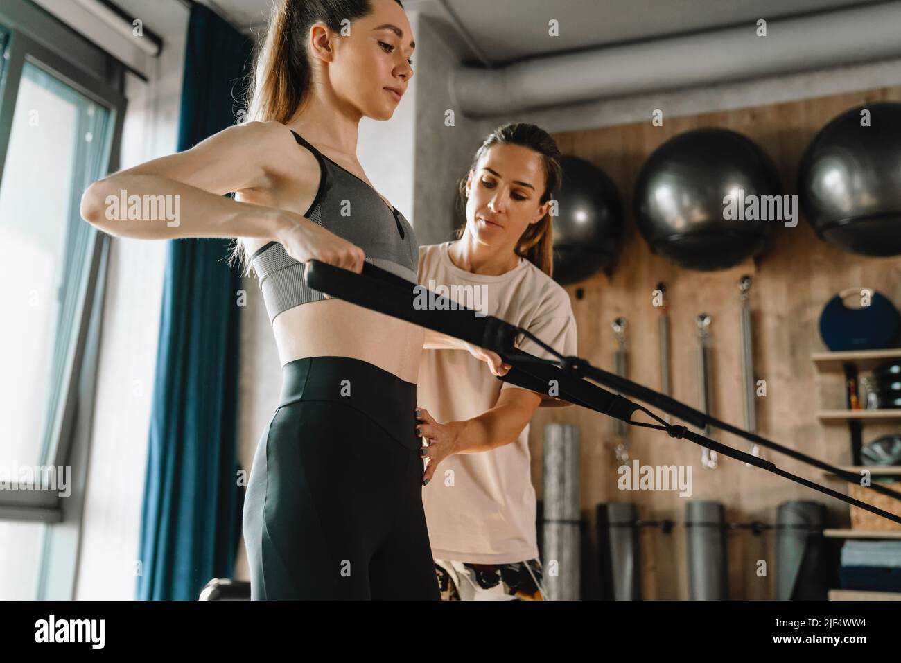 White woman working out on exercise machine during pilates class with ...