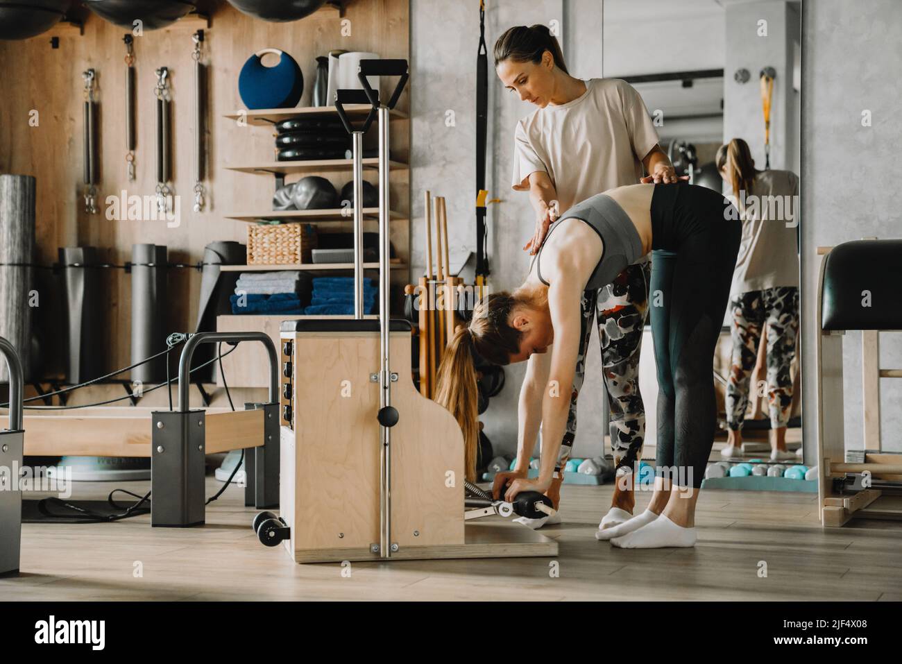 White woman working out on exercise machine during pilates class with ...