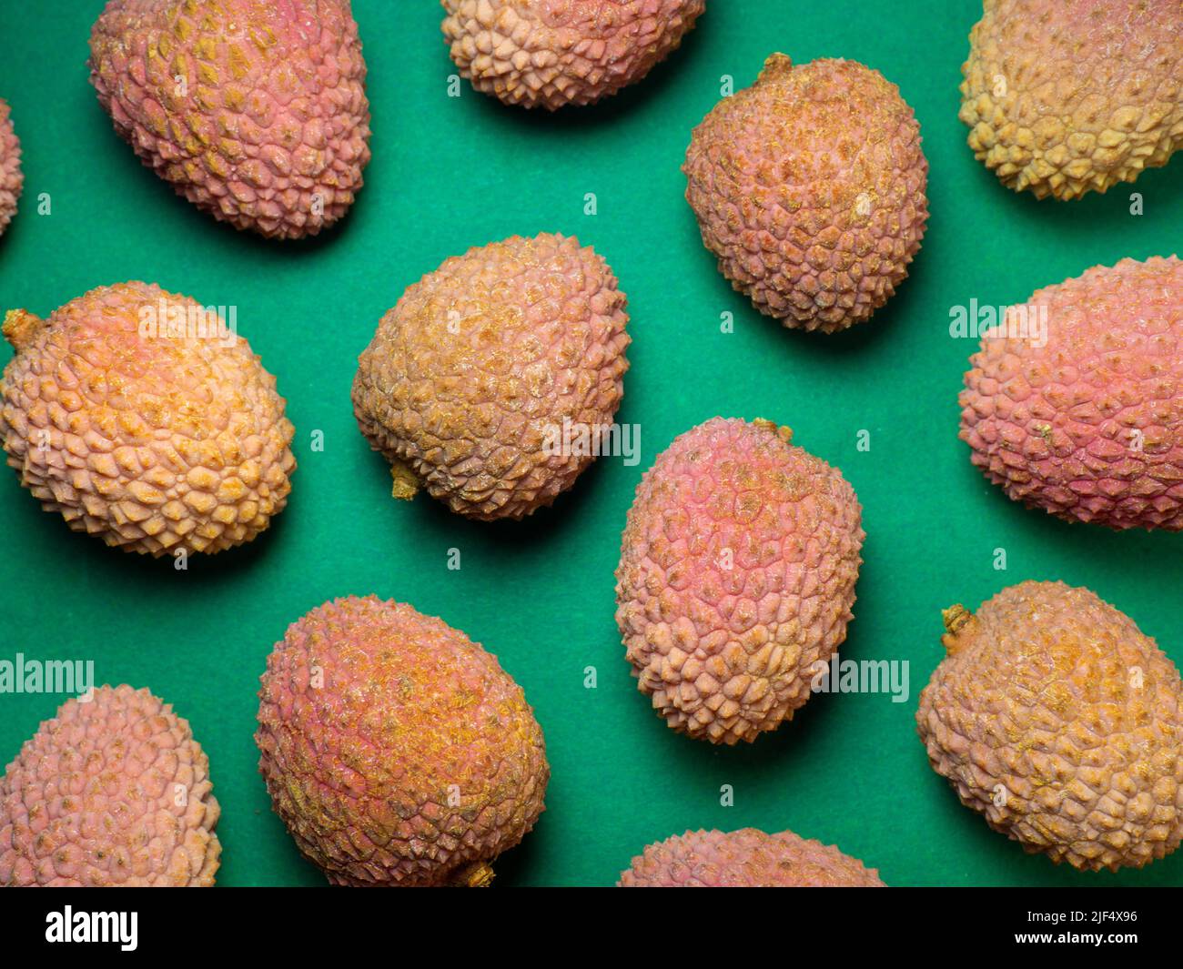 Lychee on the table. Chinese plum on a green background. Ripe fruit ...