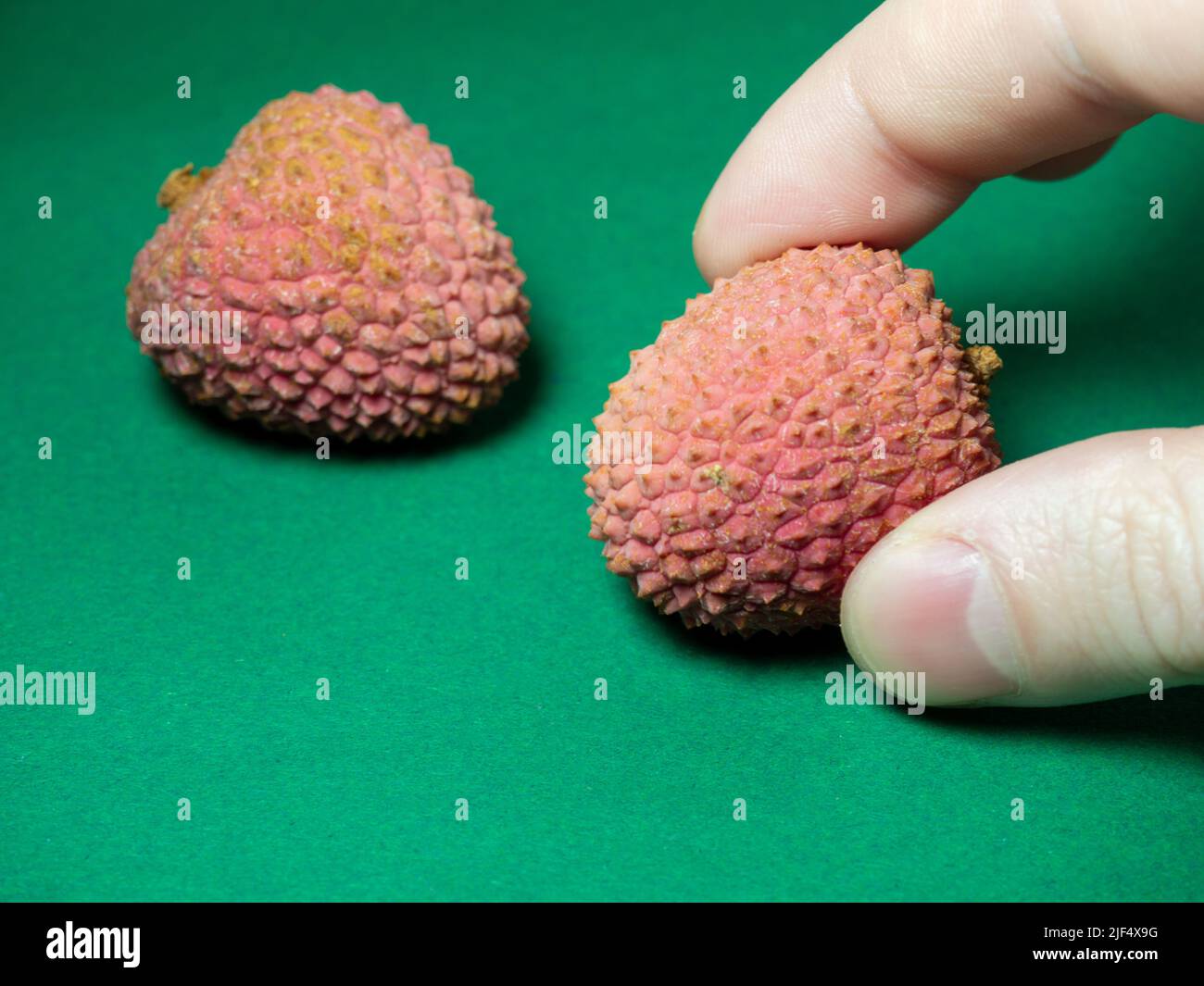 Lychee on the table. Chinese plum on a green background. Ripe fruit ...