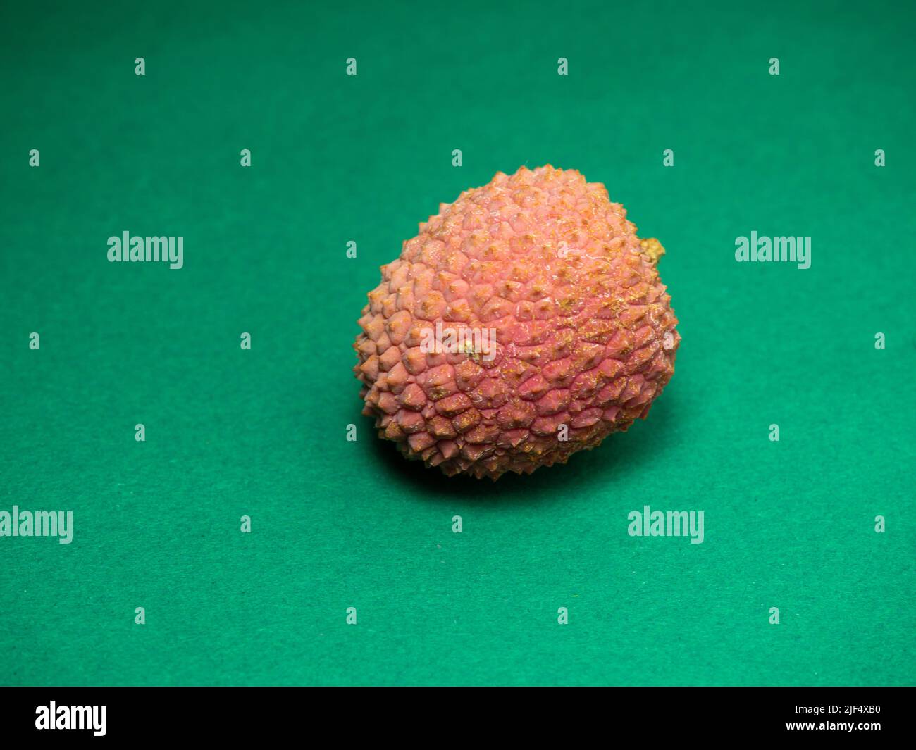 Lychee on the table. Chinese plum on a green background. Ripe fruit ...