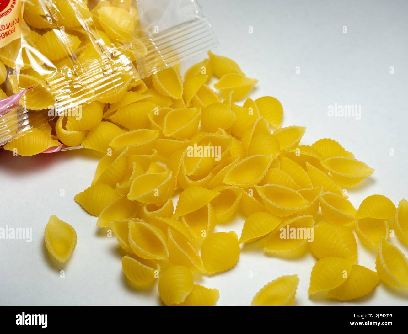 Shell-shaped pasta spills out of the package. Italian food. Cooking ...