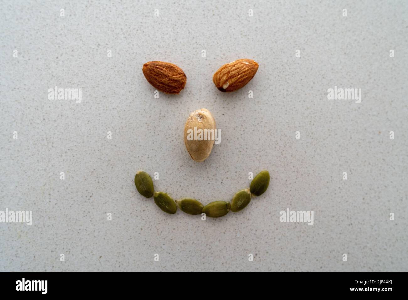 A smiley face made of almonds, pistachio and pumpkin seeds Stock Photo ...