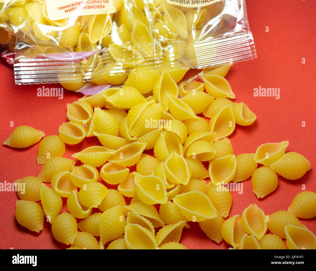 Shell-shaped pasta spills out of the package. Italian food. Cuisine of ...