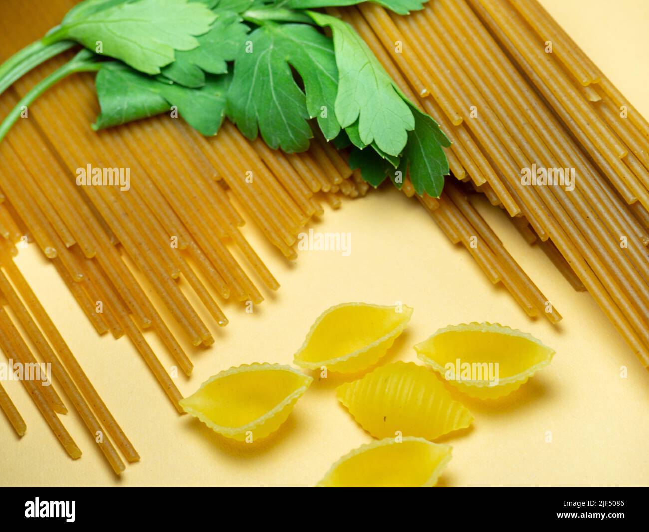 Spaghetti of two types on the table. shells and buckwheat pasta ...