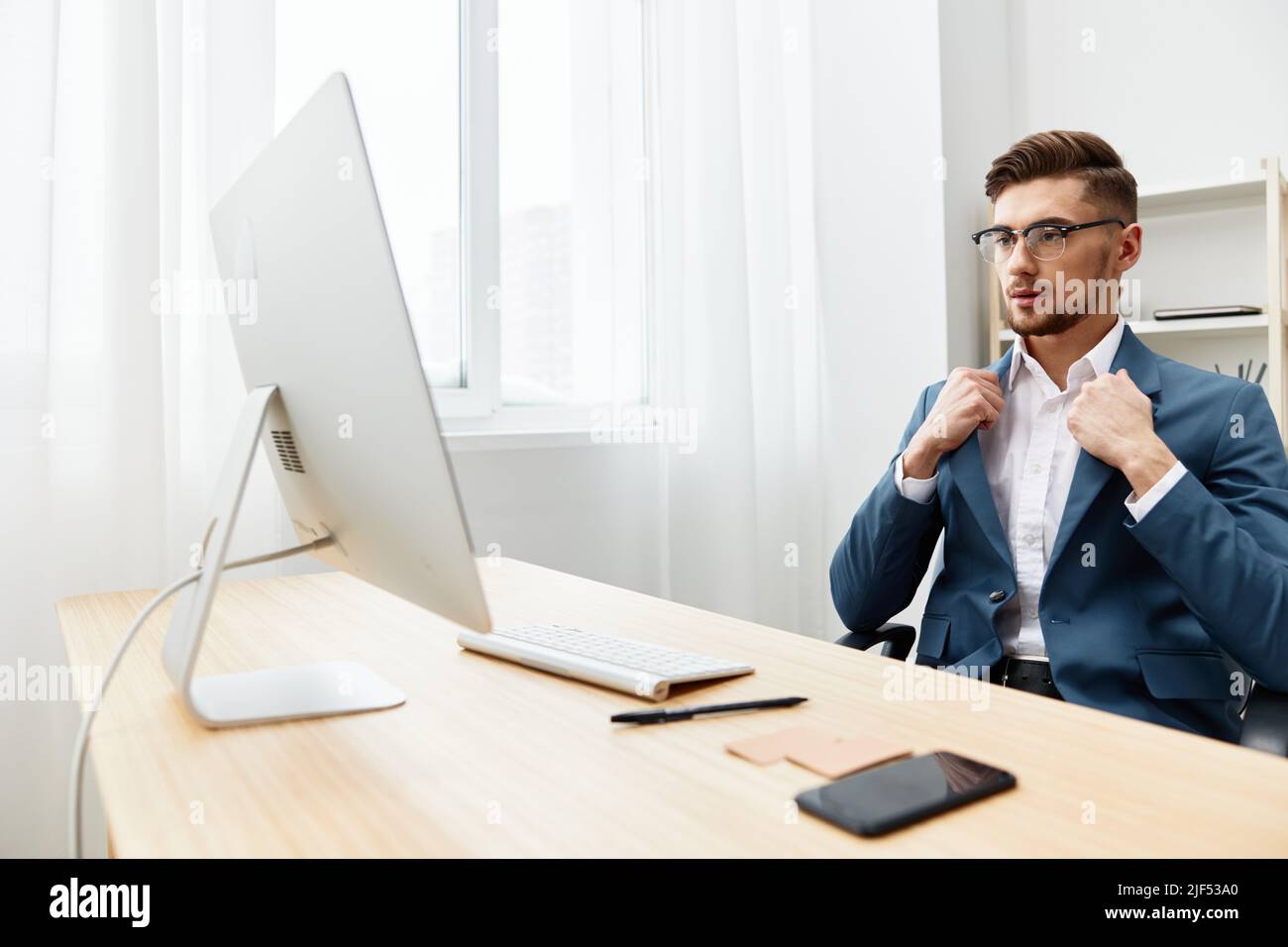 handsome businessman at the desk in the office an official executive ...