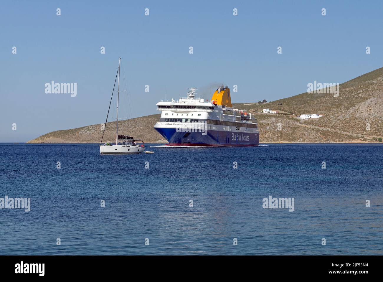 Blue Star, the Patmos ferry, manoeuvres around small sailing boat as ...