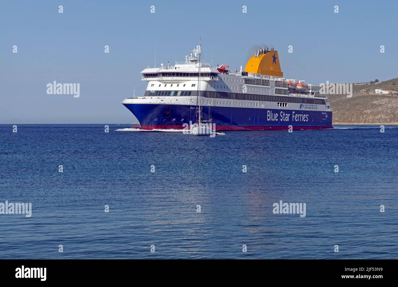 Blue Star, the Patmos ferry, manoeuvres around small sailing boat as ...