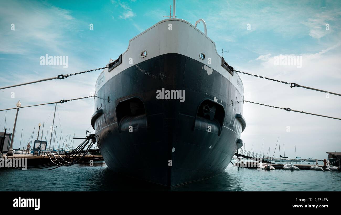 A low angle shot of the front part of an anchored ship at the harbor ...