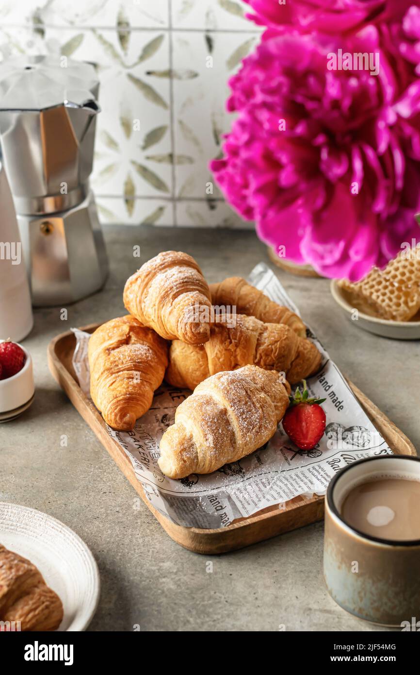 Delicious breakfast with croissants, coffee, strawberries, peonies ...