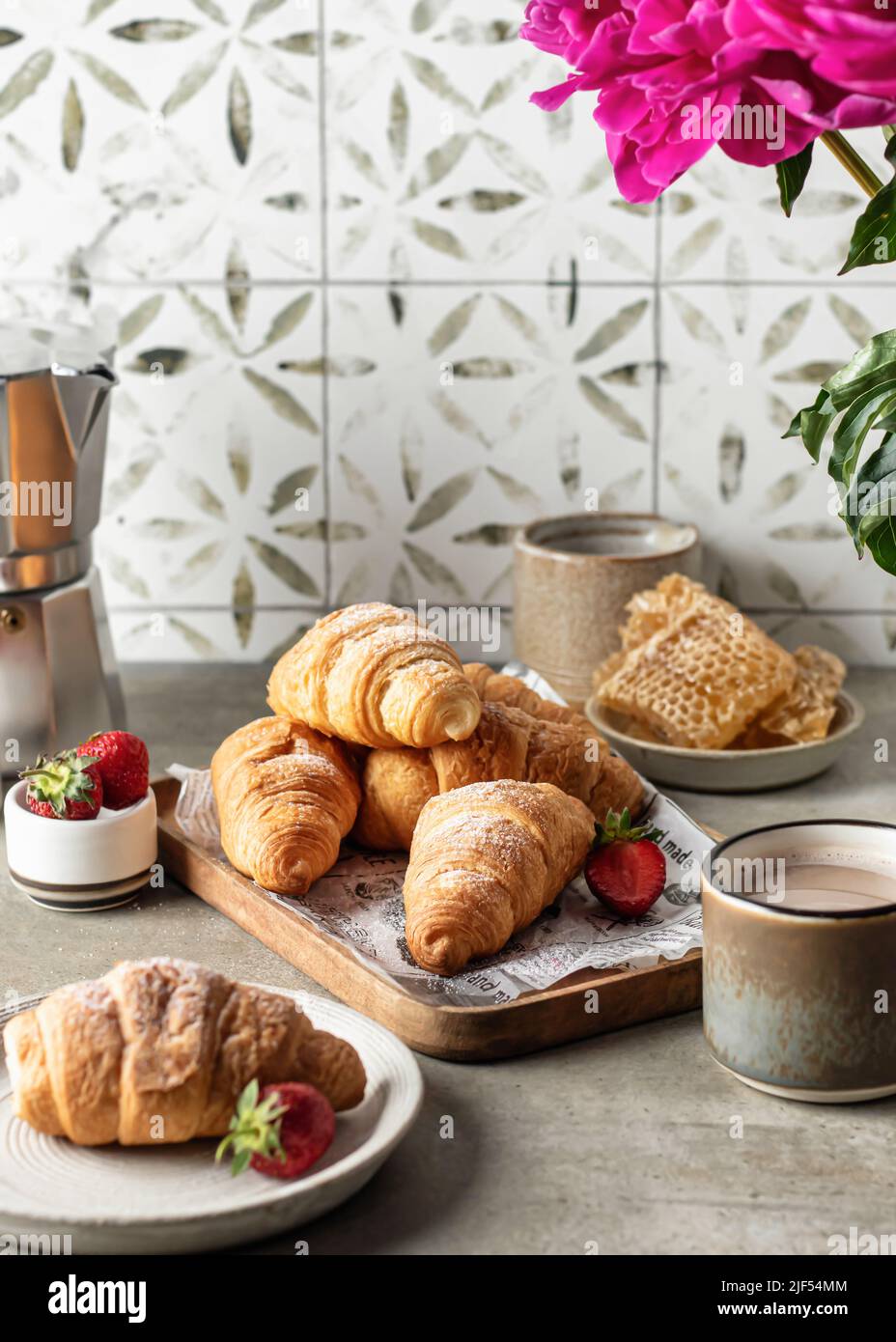 Delicious breakfast with croissants, coffee, berries, peonies flower ...