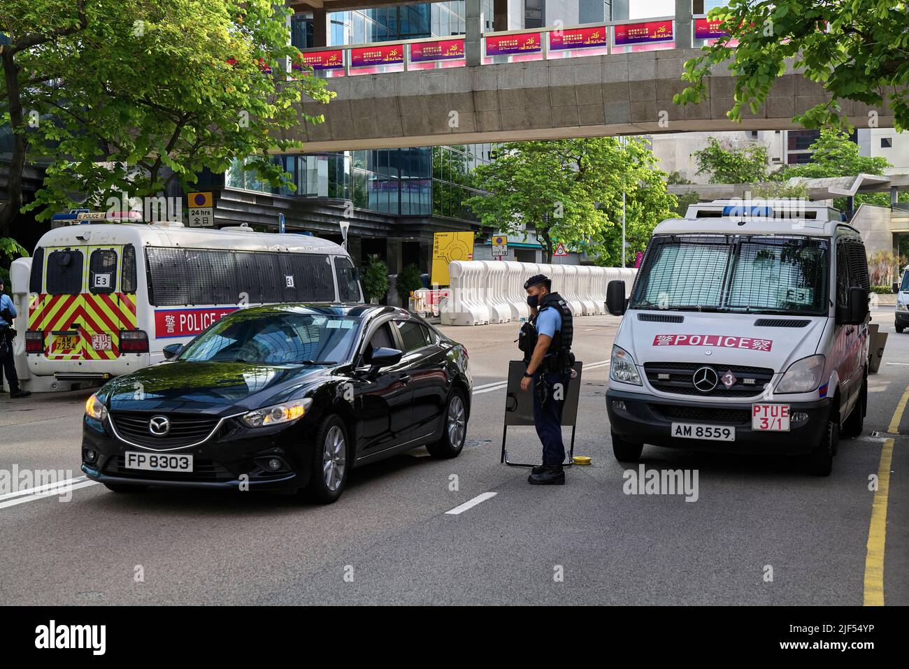 A policeman checks cars near the exhibition center in Hong Kong's Wan ...