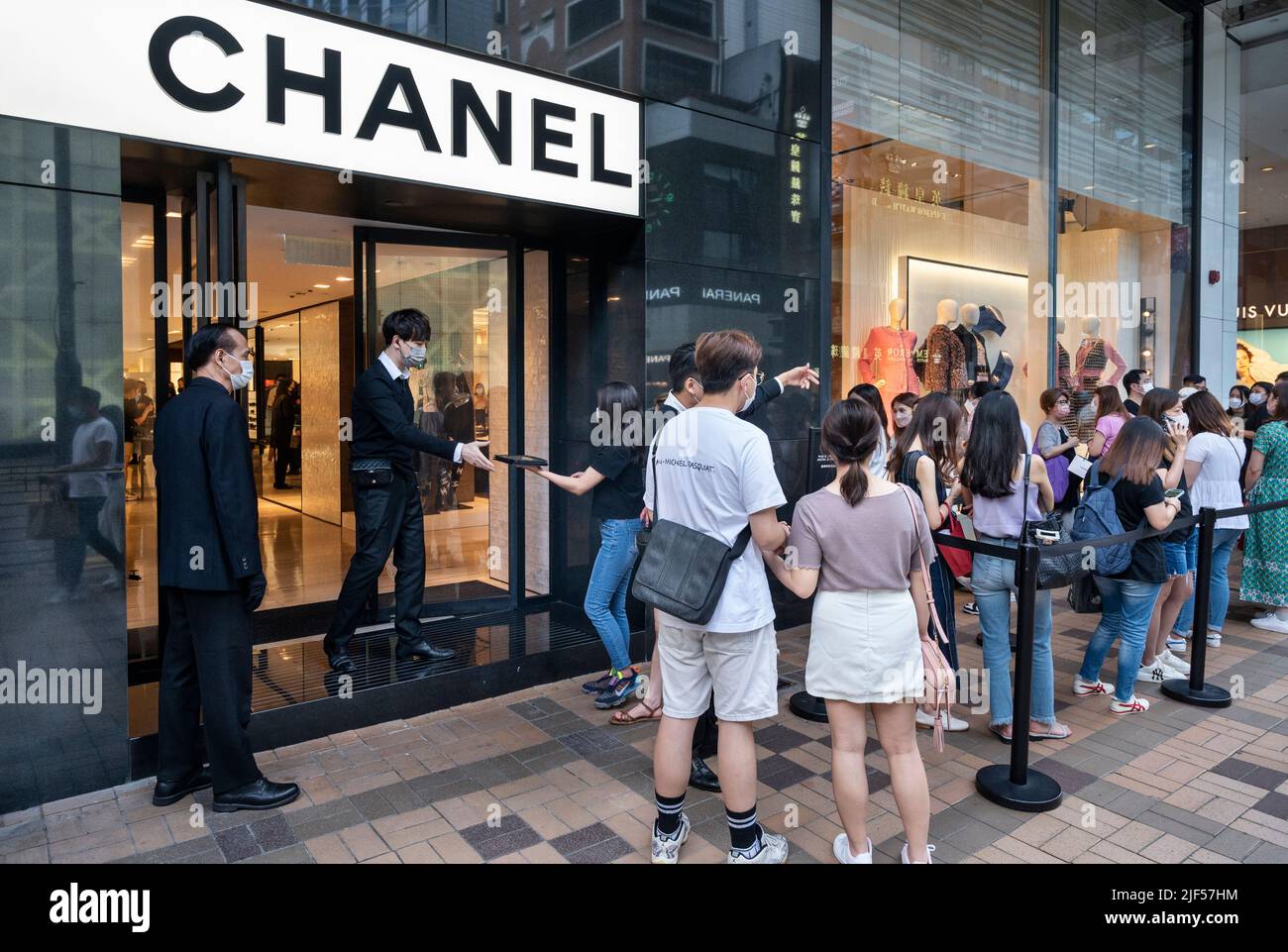 Shoppers stand in a queue at the entrance of the French multinational ...