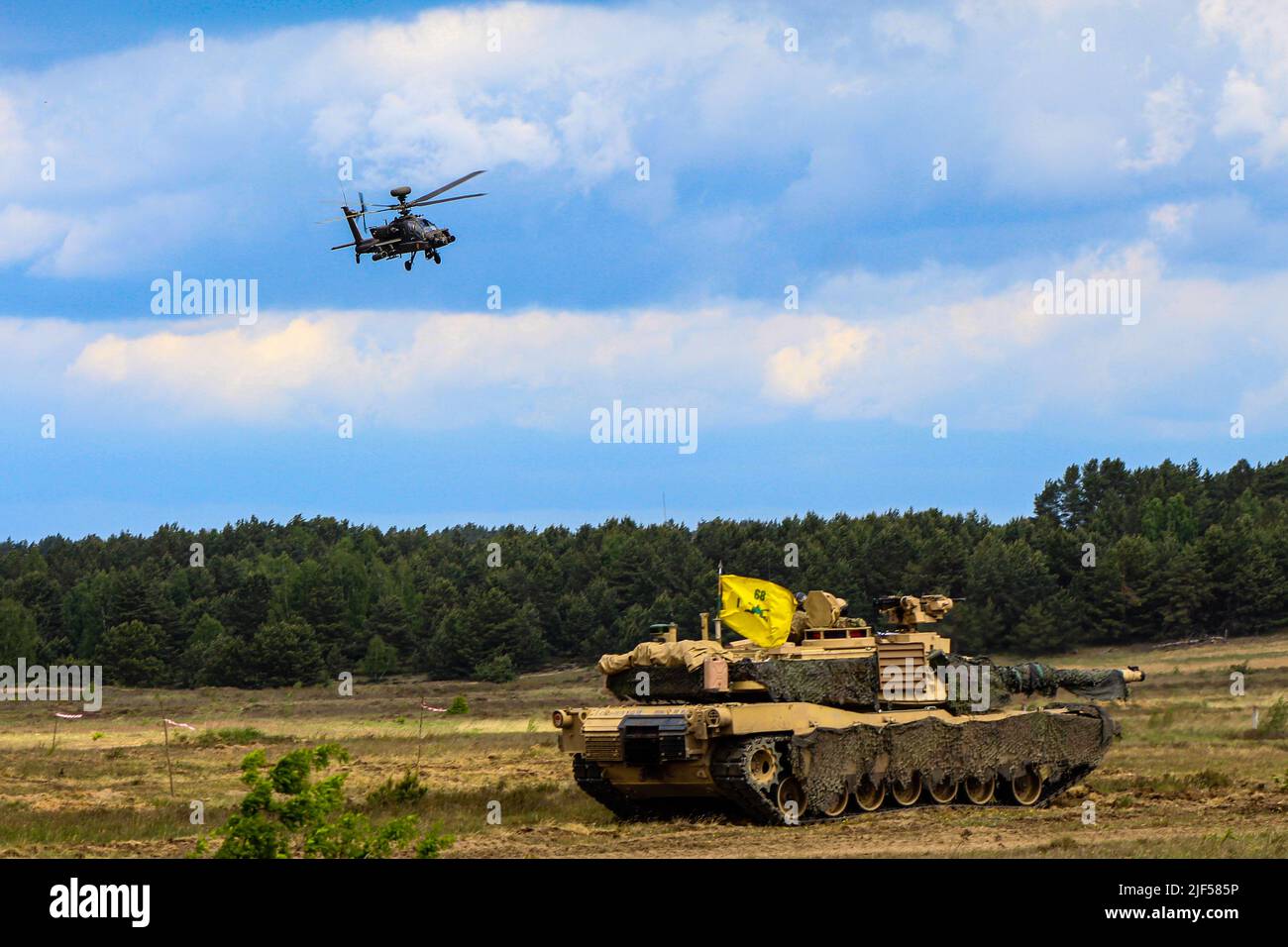 A U.S. Army AH-64E Apache Guardian attack helicopter hovers over a U.S ...
