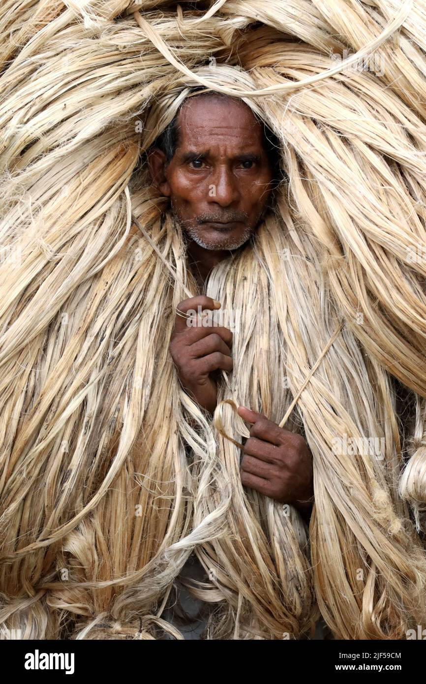 Manikgonj, Bangladesh. 29th June, 2022. A man is carrying a load of ...