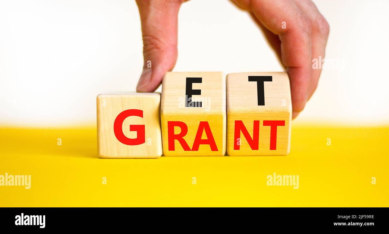 Get grant symbol. Businessman turns wooden cubes with concept words Get ...