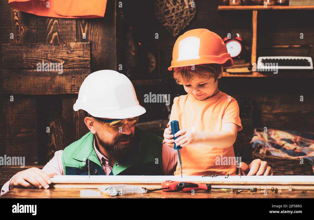 Father and sons are are building the furniture at home. Little ...