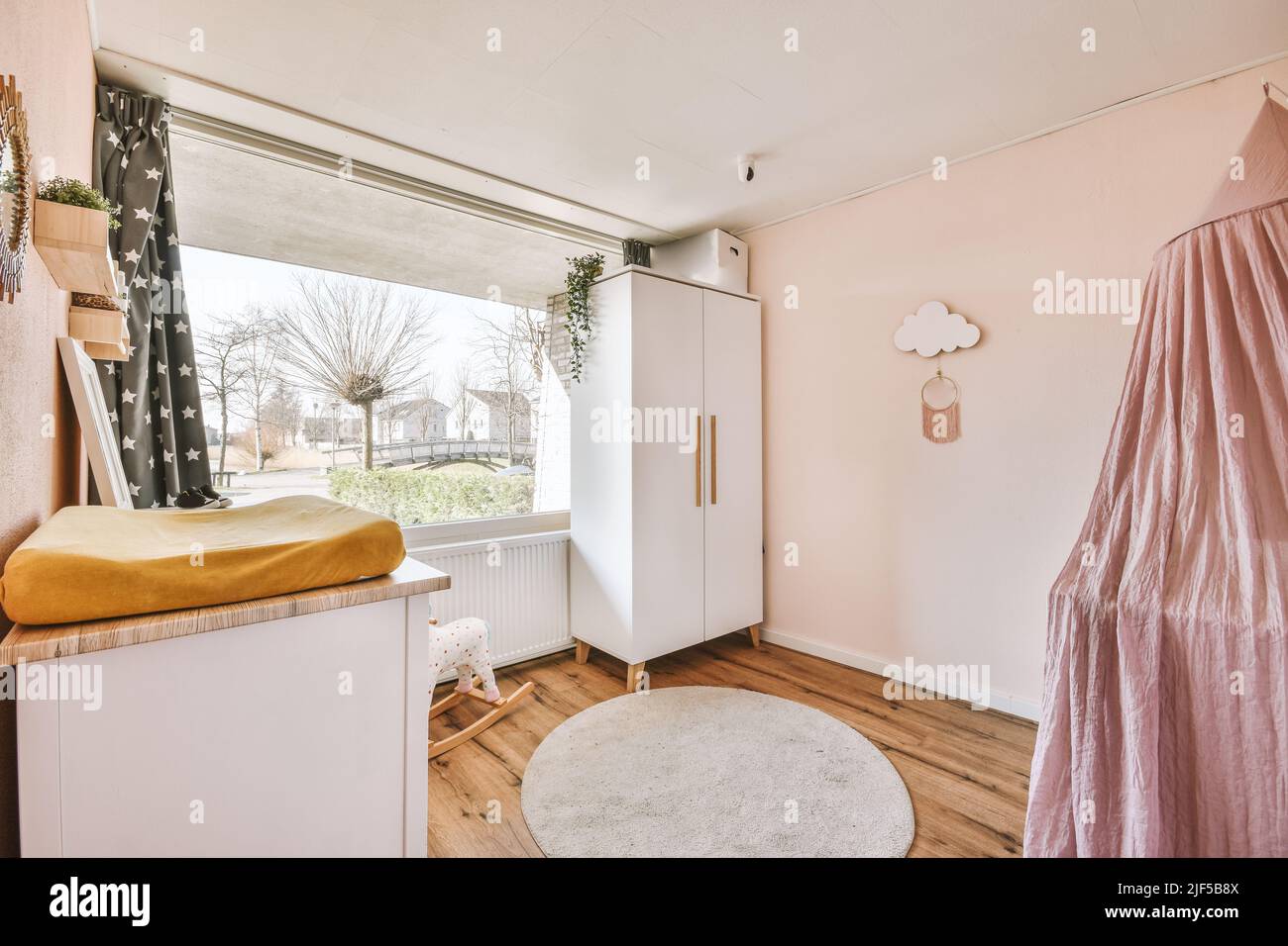Cozy children's room with a large window, pink walls, a soft round ...