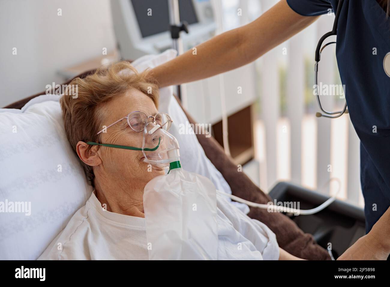 Doctor putting a breathing mask on a female patient with covid-19 in ...