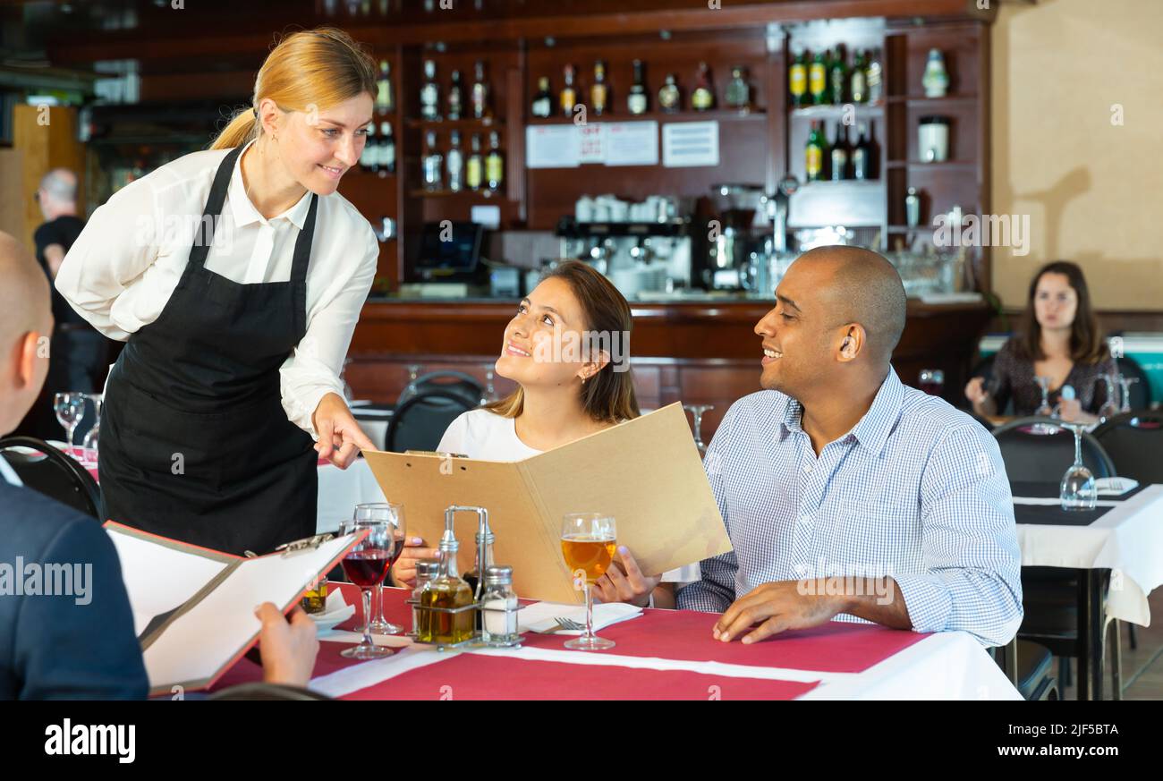 Polite waitress taking order from guests in pizza restaurant Stock ...