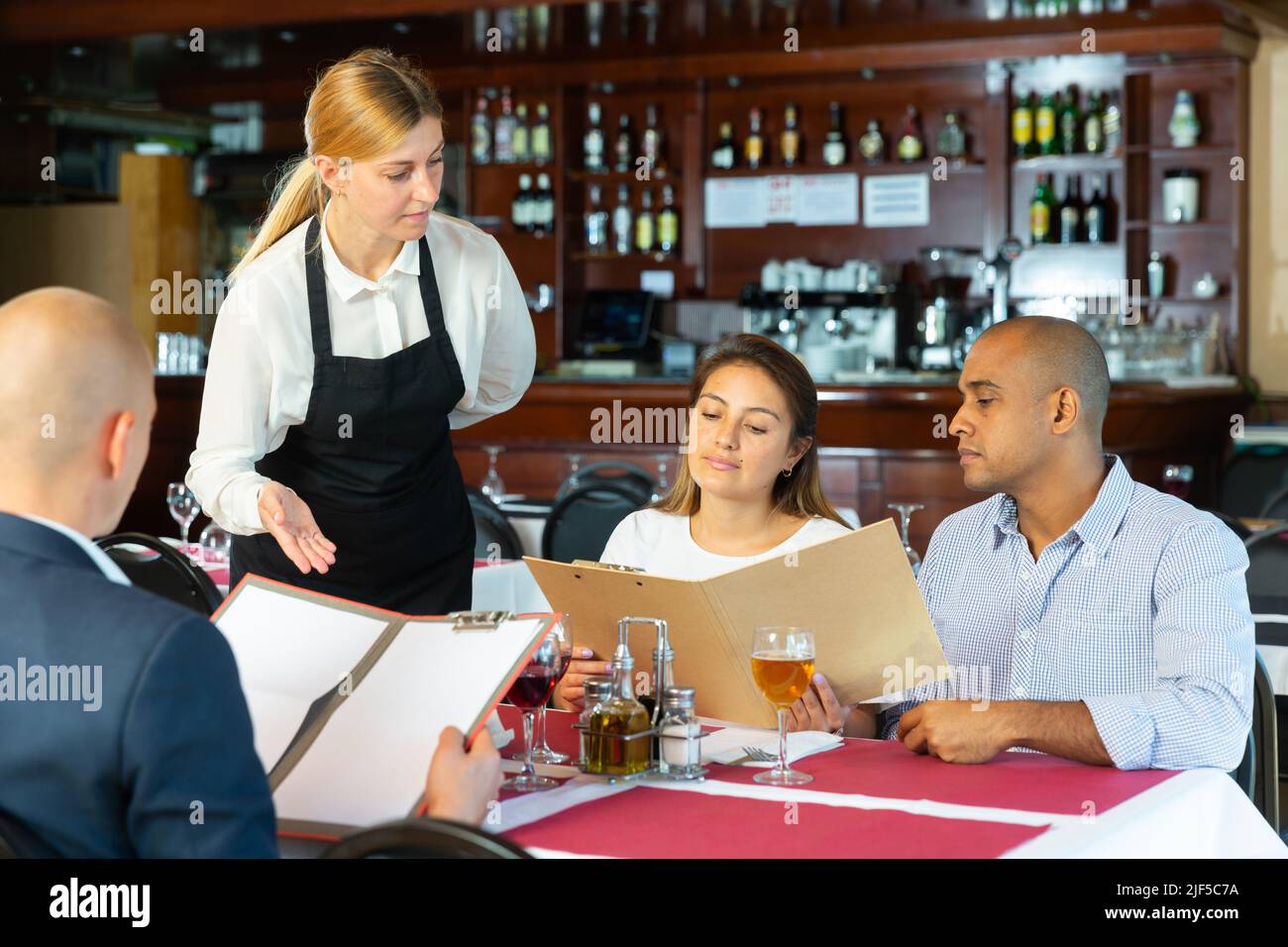 Polite waitress taking order from guests in pizza restaurant Stock ...