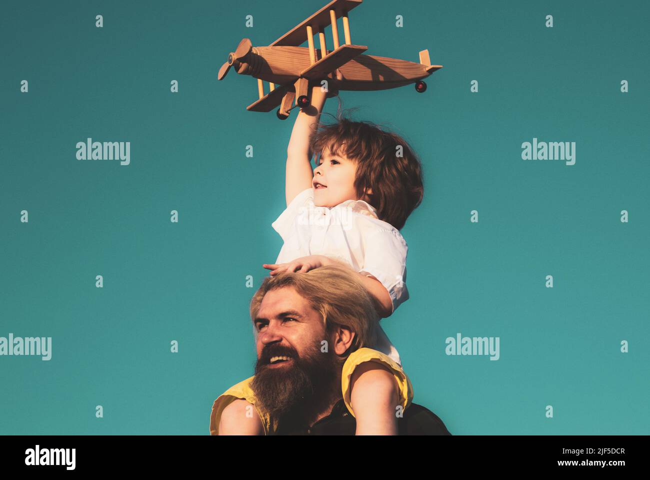 Boy with airplane sitting on fathers shoulders. Father and son together ...