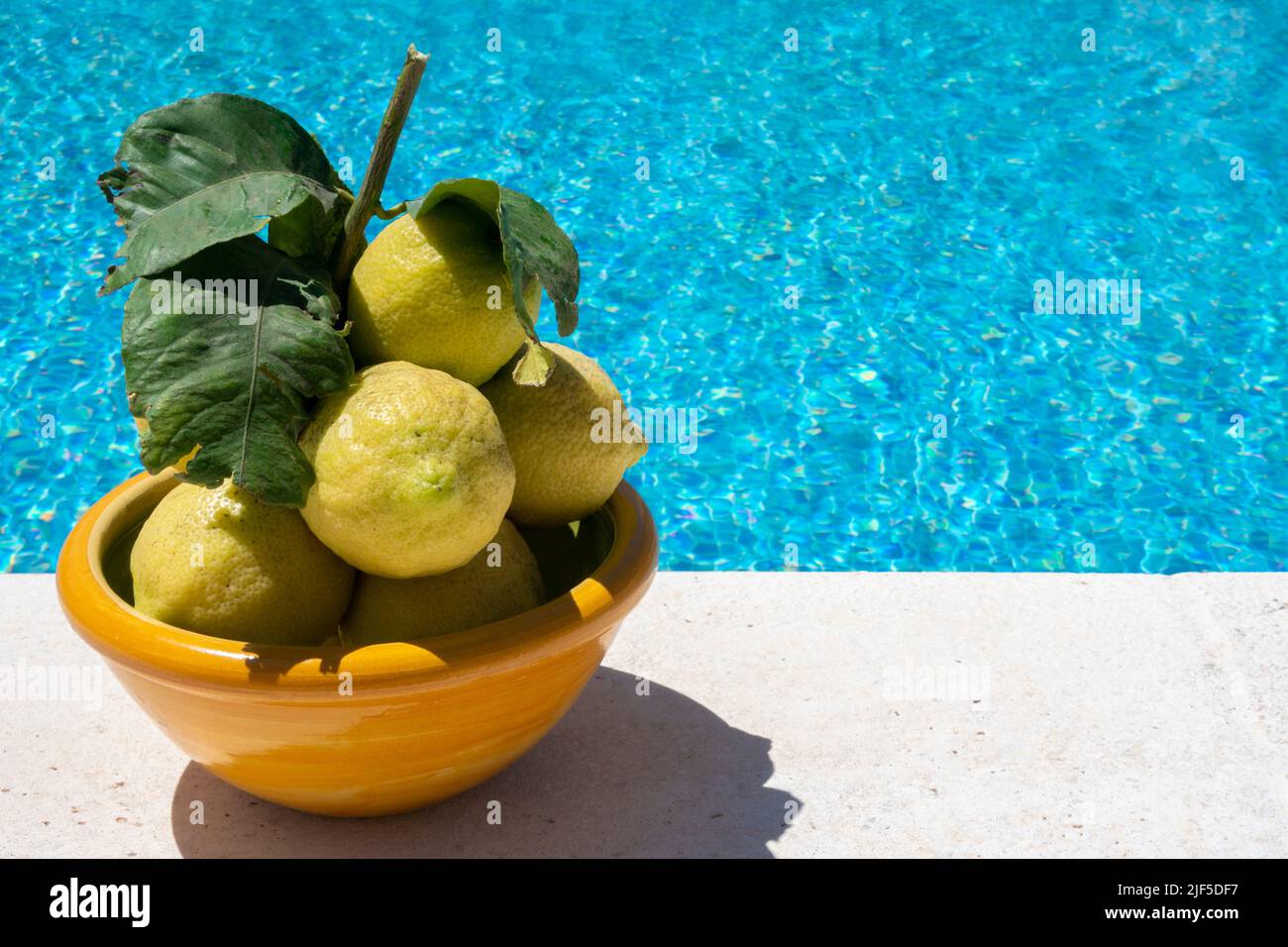 Fruit bowl with a bunch of organically grown lemons by the pool Stock ...