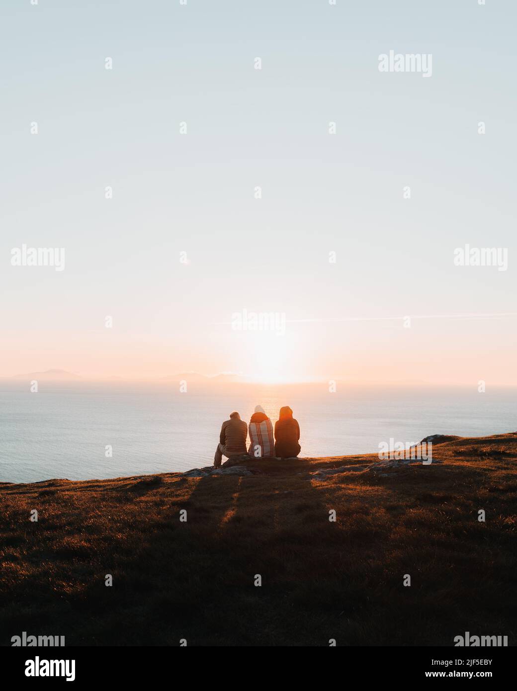 A vertical shot of a group of friends enjoying the view from a cliff ...