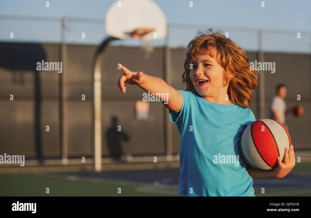 Kid playing basketball with basketball ball. Child pointing showing ...