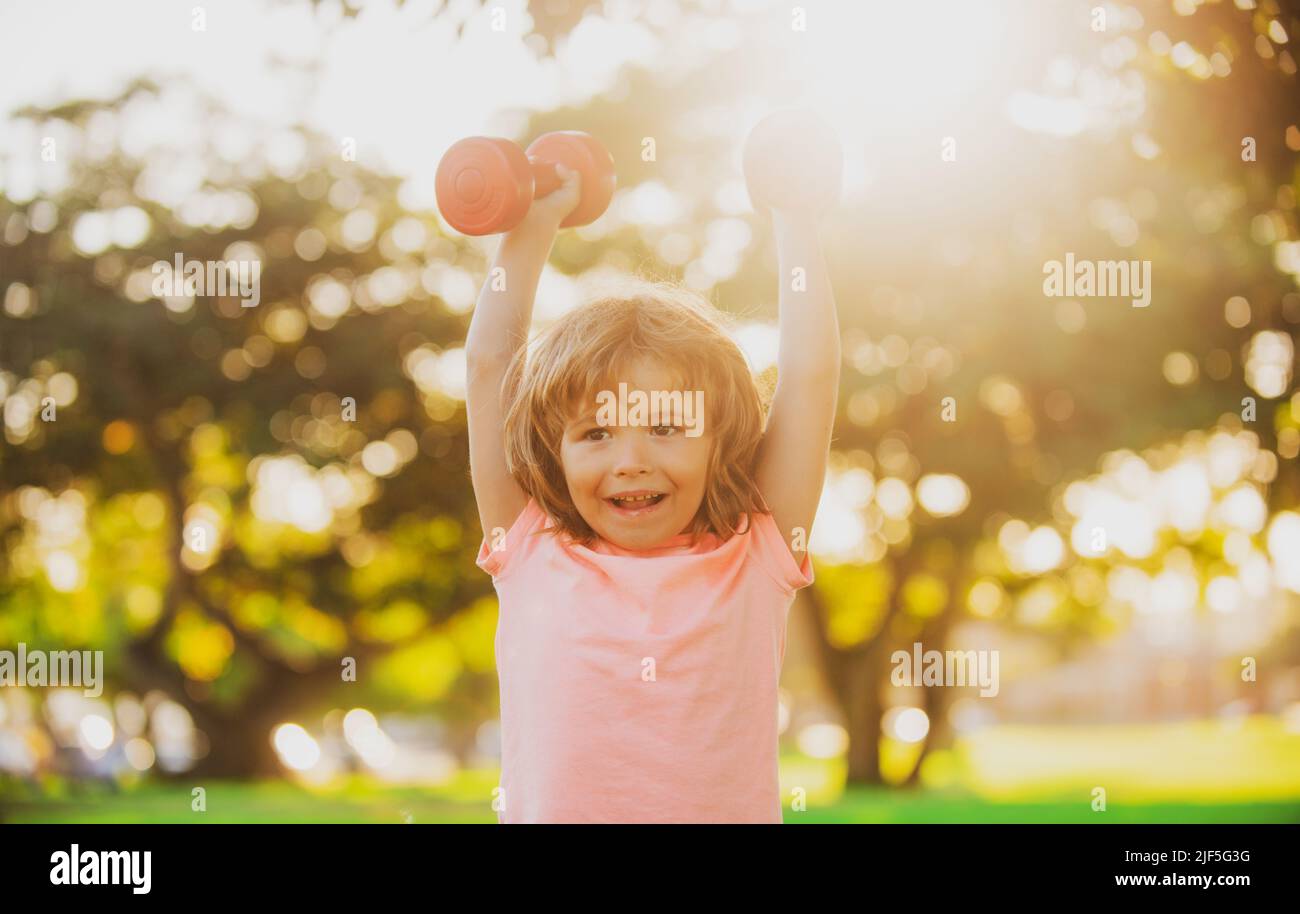 Happy child exercising outdoor. Boy workout with dumbbell in park ...