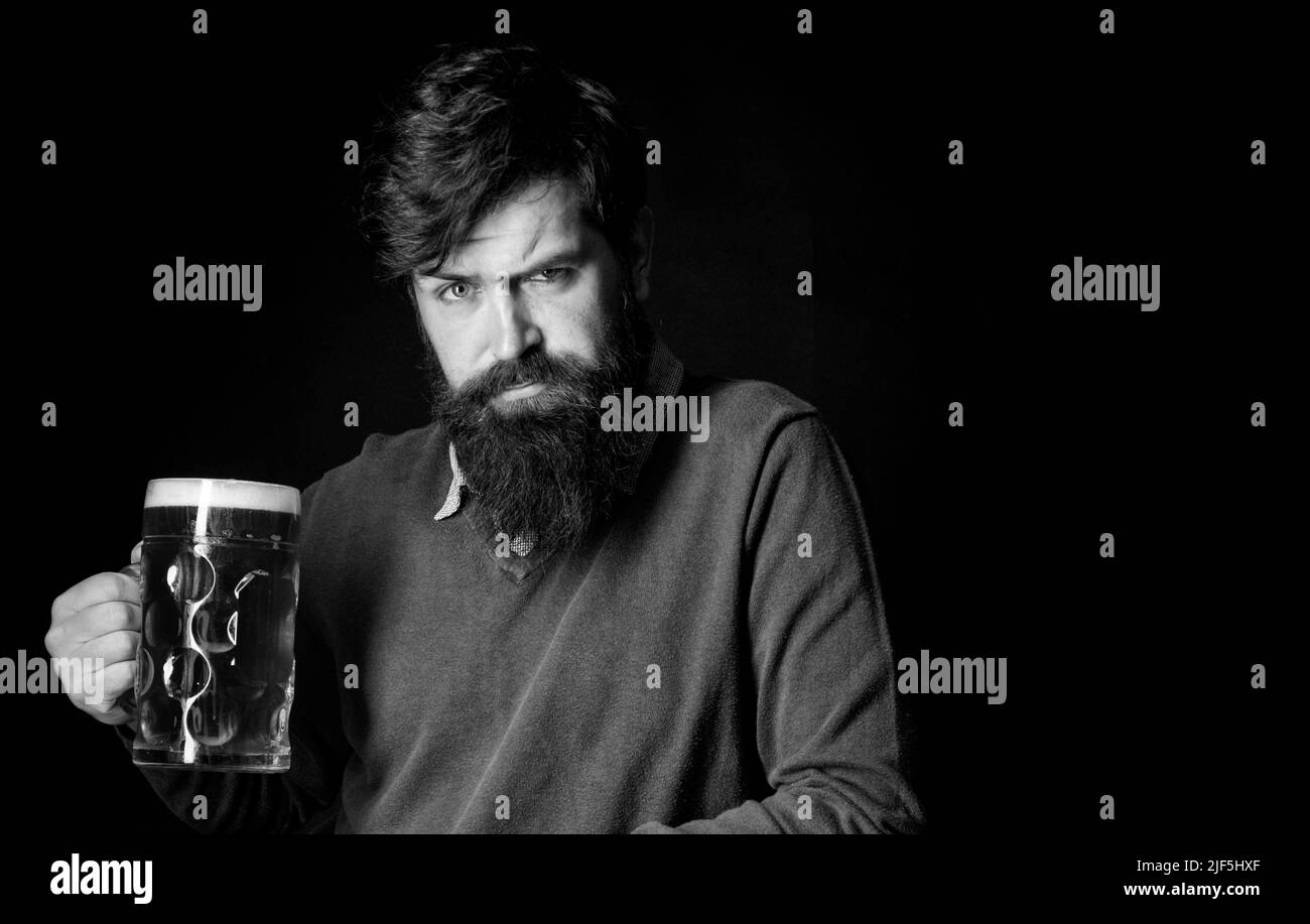 Stylish handsome man in black suit drinking beer over Black background ...