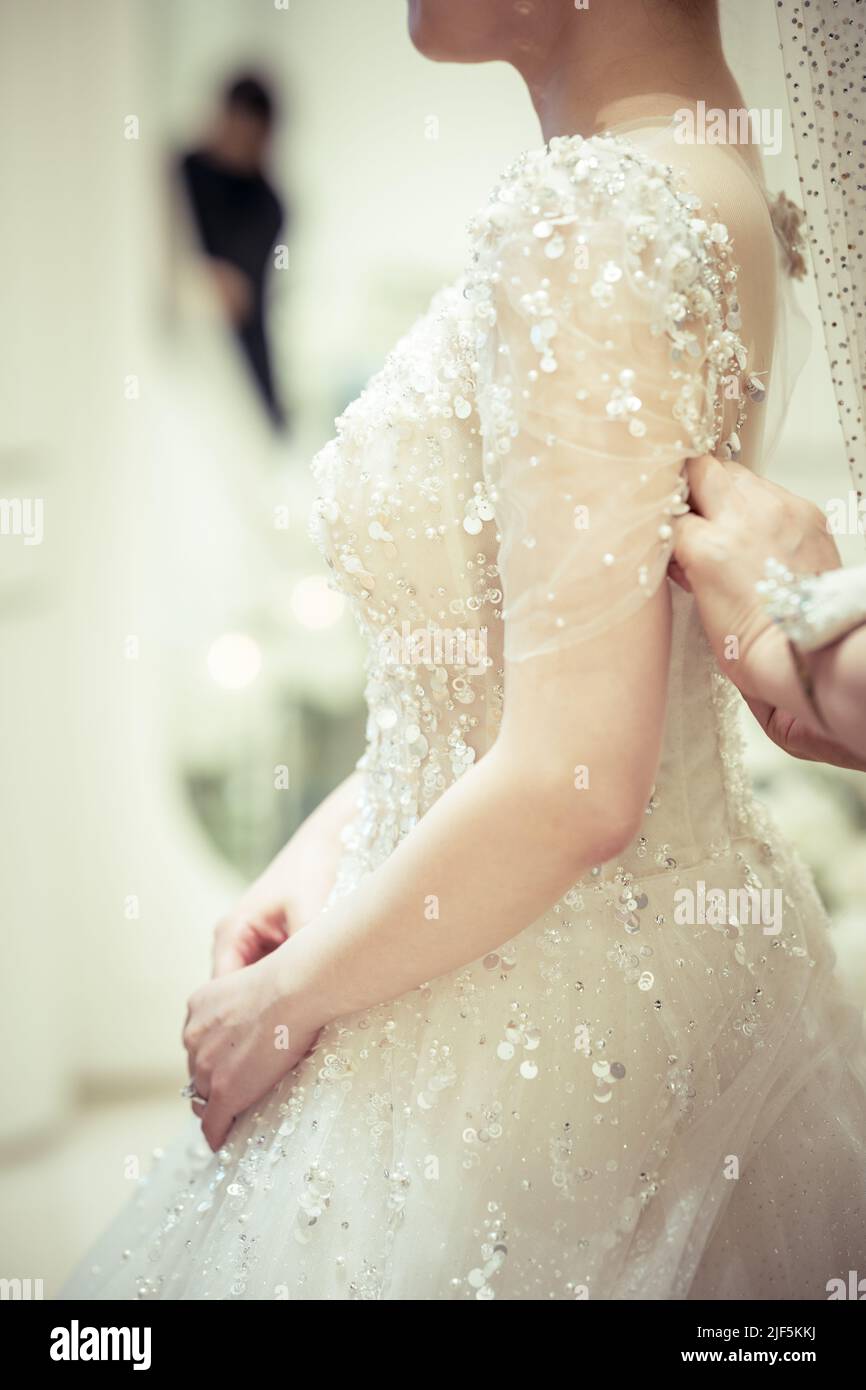 Bridesmaids fixing brides wedding dress. Concept image Stock Photo - Alamy