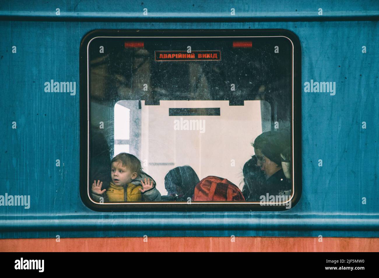 Ukrainian boy is looking outside the window. The train station in Lviv ...