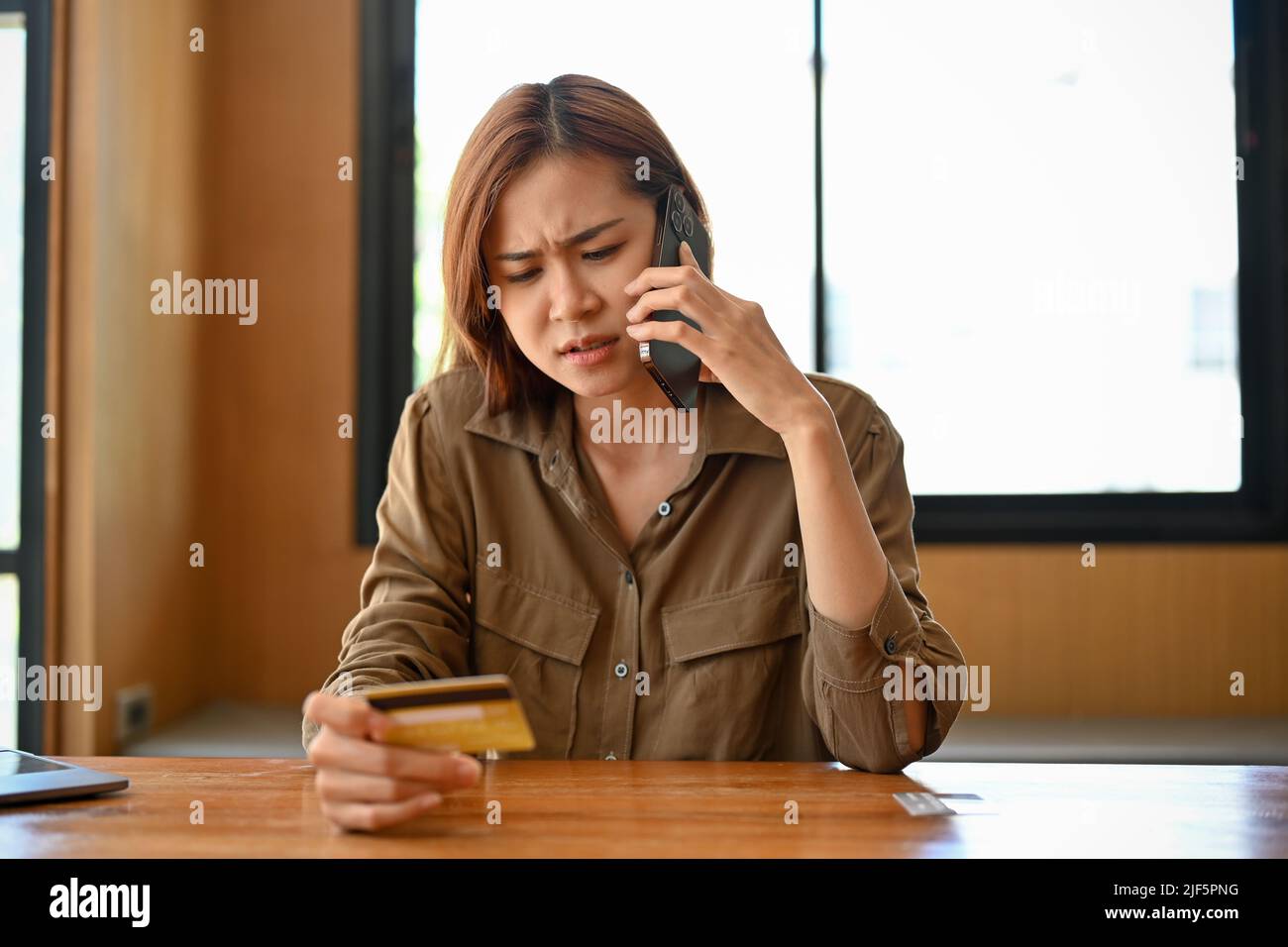 Serious young asian woman complaining her credit card problems with ...