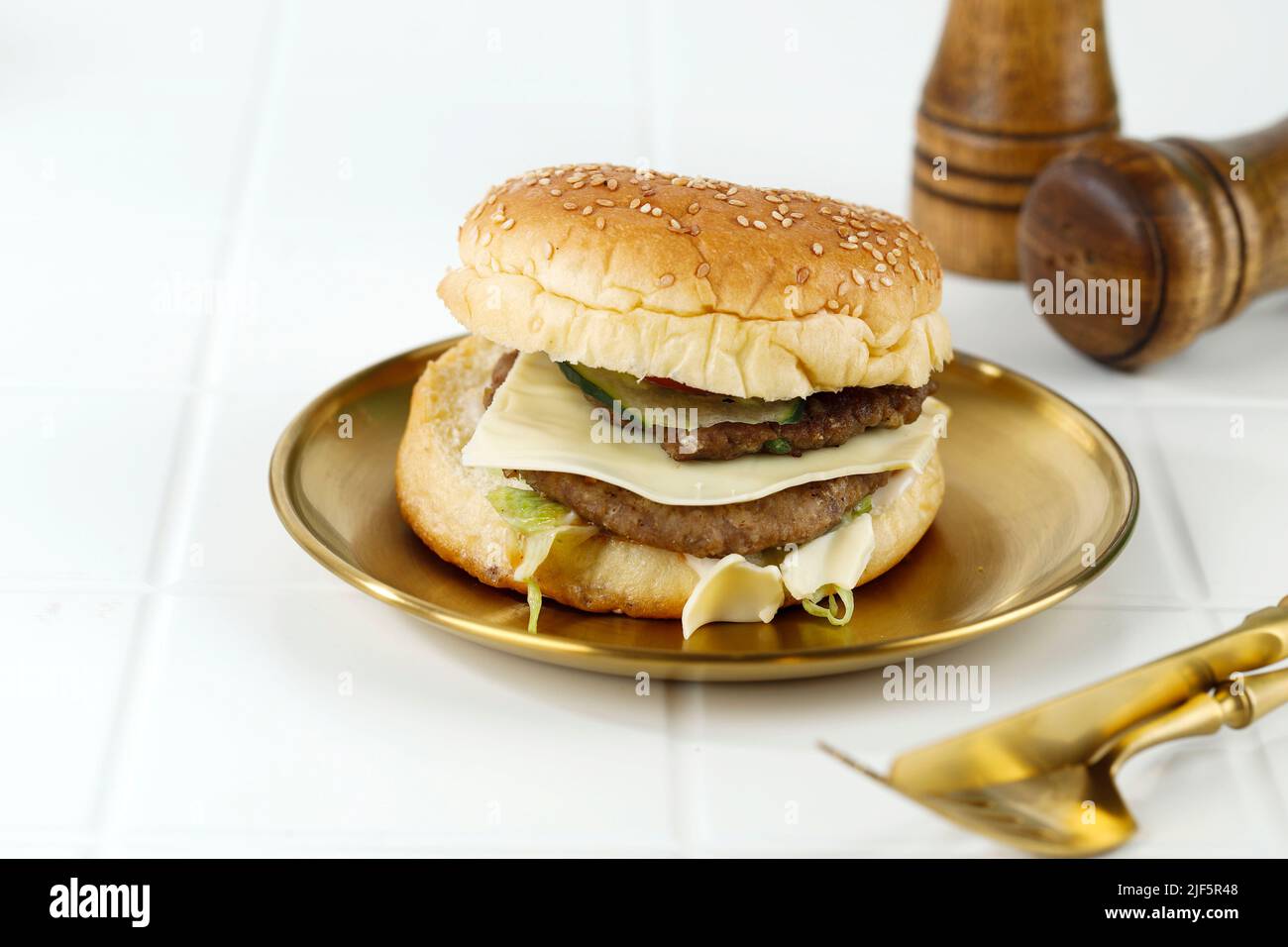 Homemade Premium Cheese Hamburger on Golden Plate, White Table Stock ...