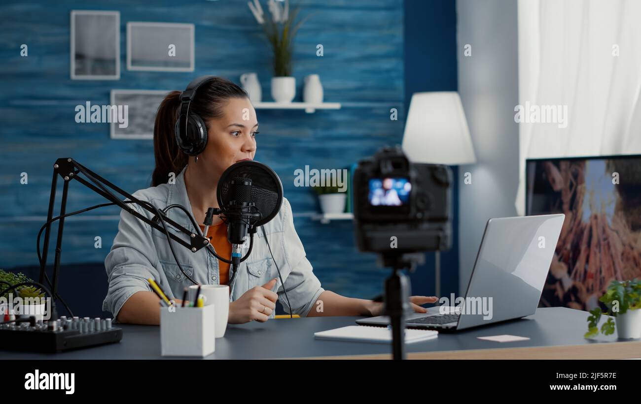 Creative content creator putting headphones on while recording vlog ...