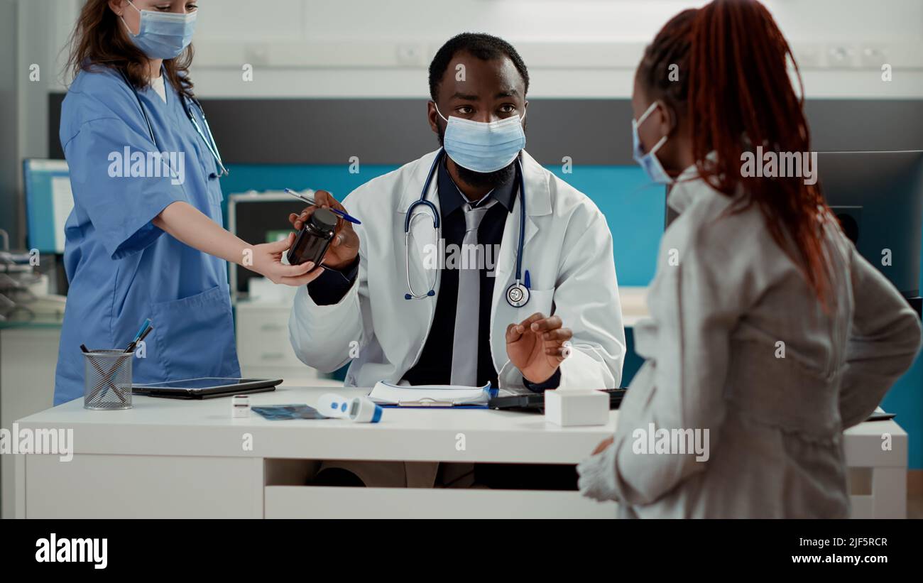 General practitioner giving bottle of pills as prescription treatment ...
