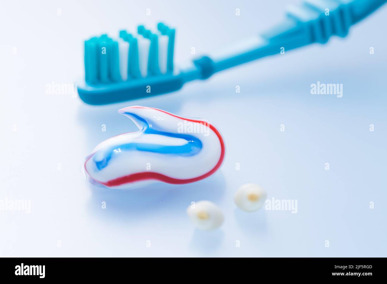 Colorful toothpaste and toothbrush with primary teeth on blue ...